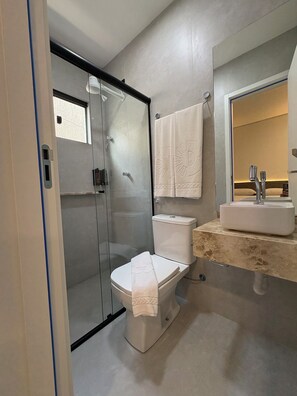 Quarto triplo conforto | Banheiro | Chuveiro, toalhas de banho, sabonete, shampoo