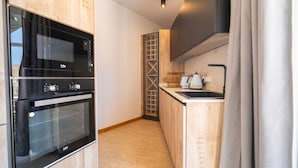 Uma cozinha compacta com forno embutido, pia e armário de madeira.