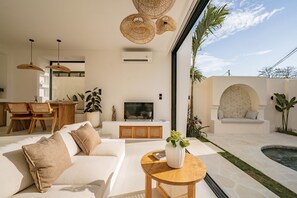 Vila luxo, 1 cama King, vista para a piscina | Sala de estar | TV 43 polegadas com canais a cabo