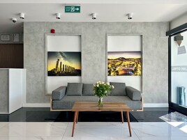 Um hall moderno com um sofá, uma mesa de centro e duas fotografias emolduradas na parede.