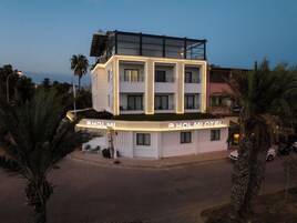 Um hotel de vários andares com uma placa grande que diz 'HOLMI HOTEL'.