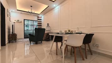 Uma sala de jantar com mesa, cadeiras e um candelabro.