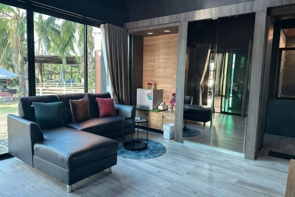 Uma sala de estar moderna com sofá modular, uma mesinha e vista para o exterior.
