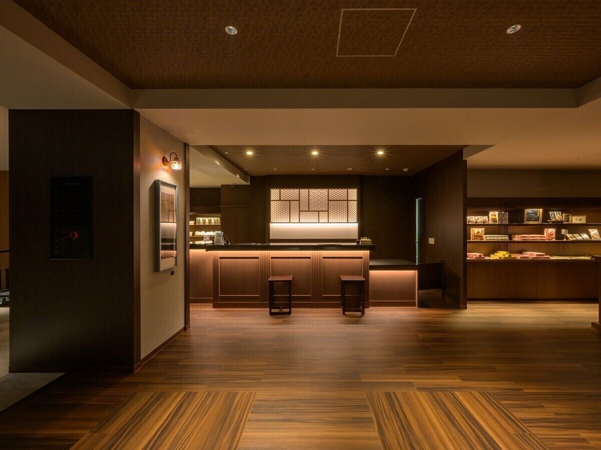 Um interior moderno com piso de madeira, área de bar e balcão de recepção.