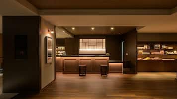 Um interior moderno com piso de madeira, área de bar e balcão de recepção.
