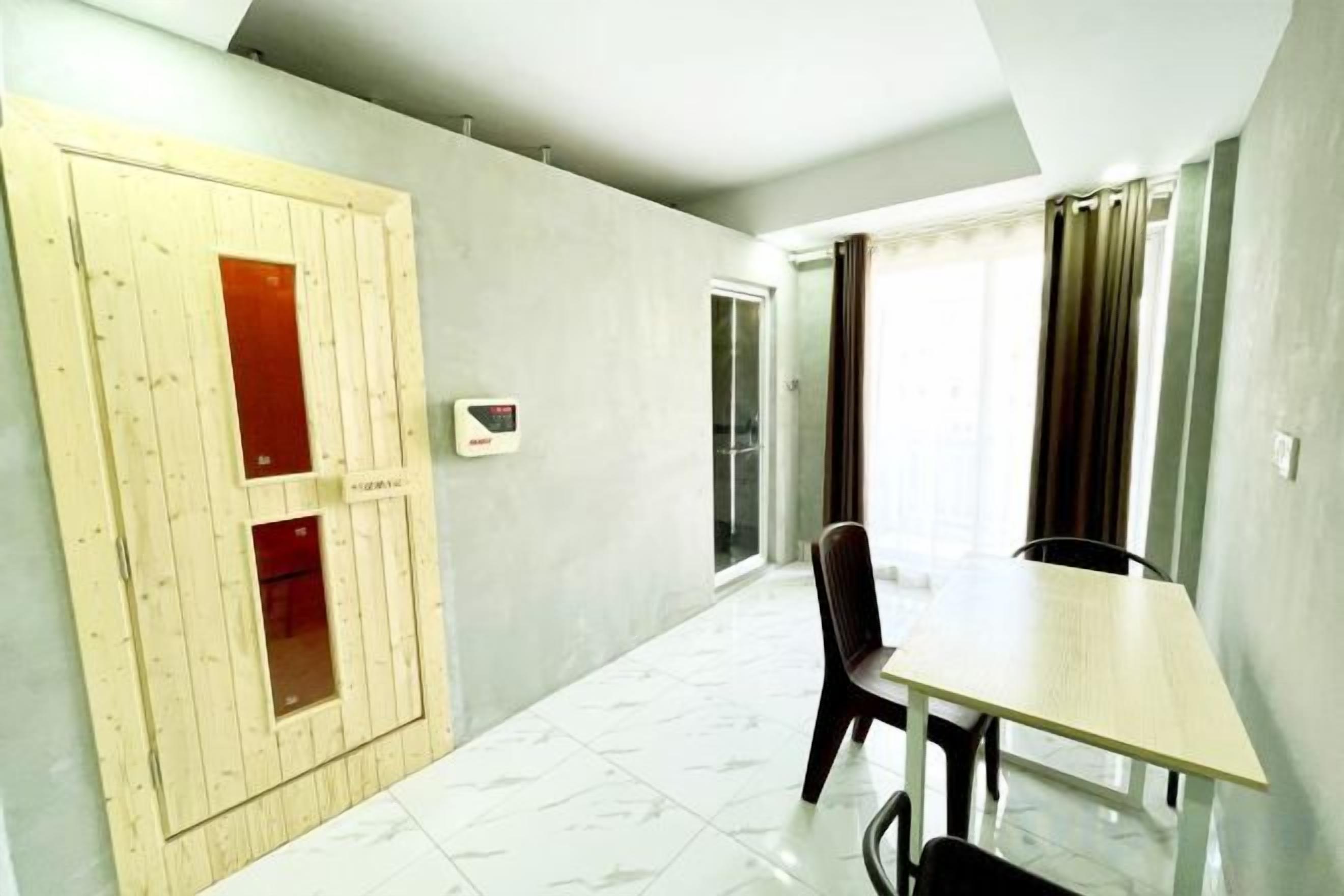 Um quarto com porta de madeira, mesa de jantar e cadeiras.