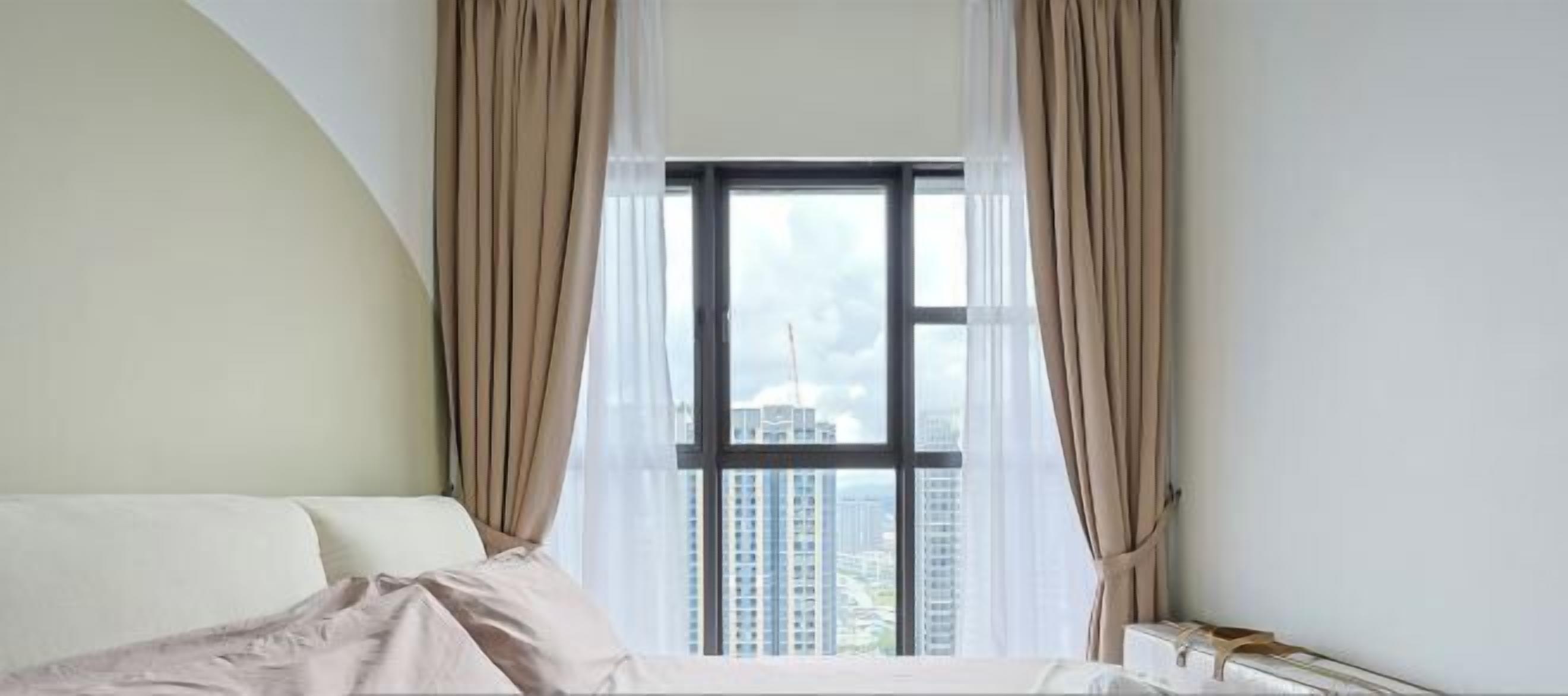 Quarto de hotel com uma janela grande, uma cama e cortinas.