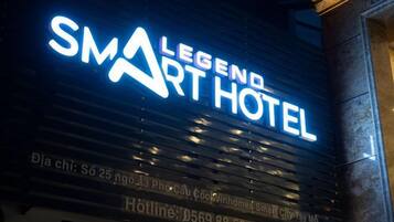 Placa de hotel com o nome 'Legend Smart Hotel' e um número de telefone.