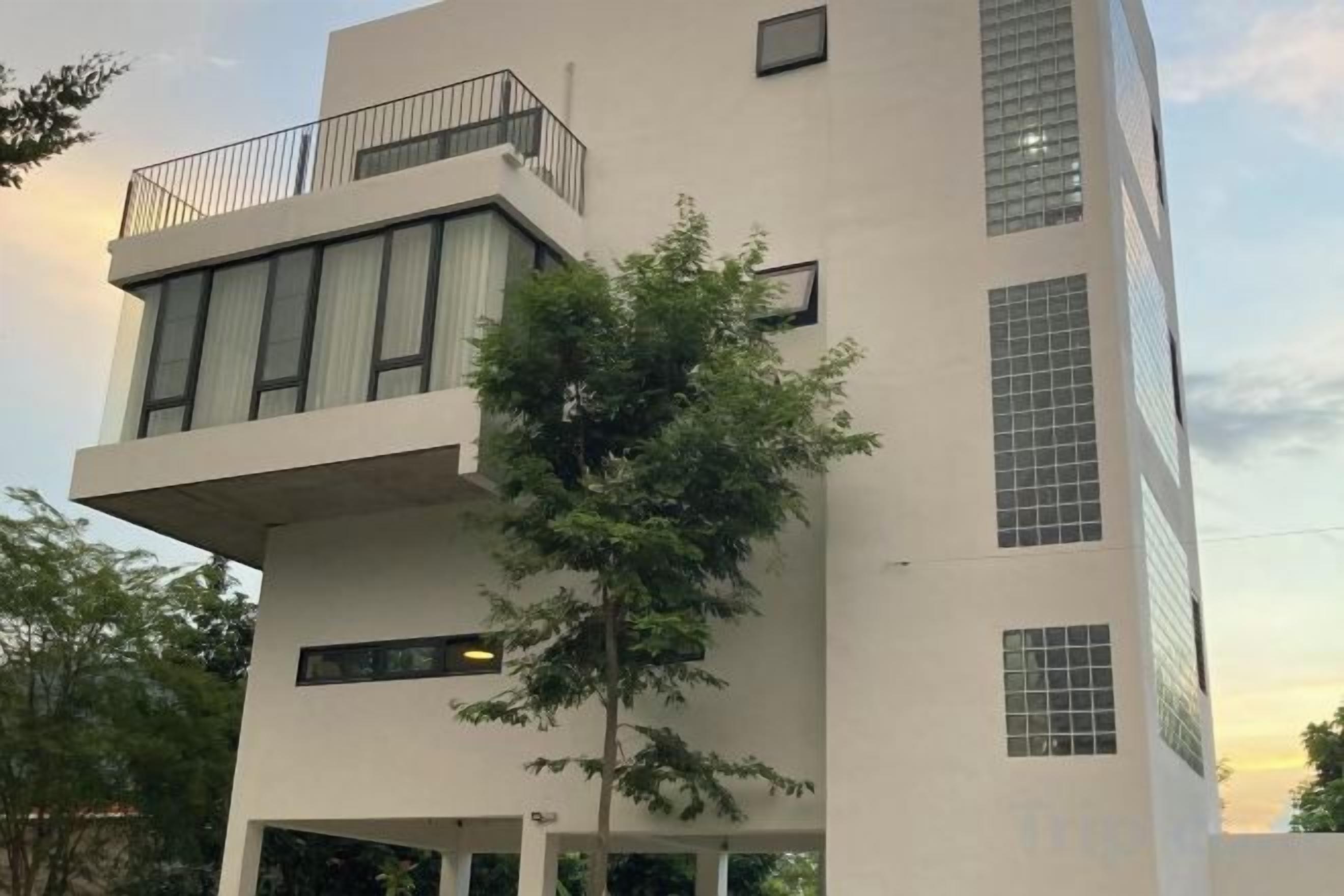 Um edifício moderno com fachada plana, grandes janelas e uma varanda.