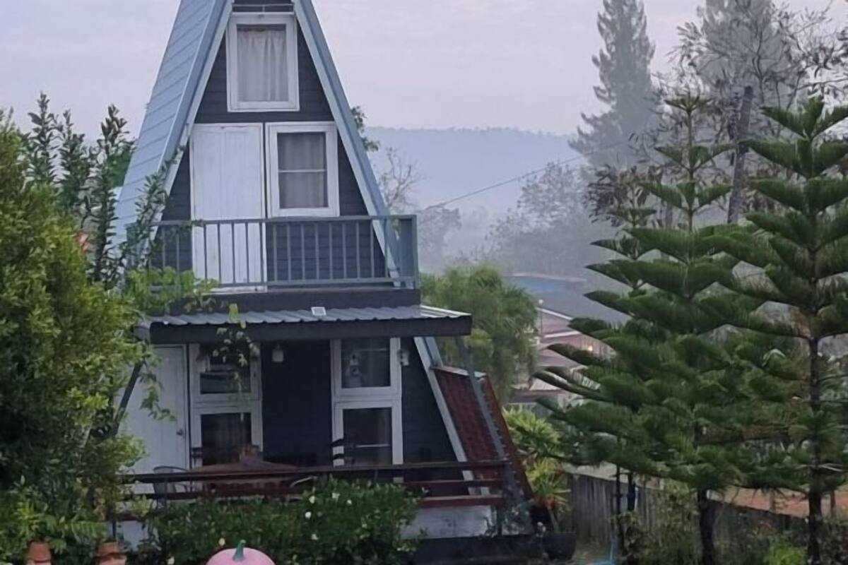 Um edifício triangular com varanda e um pequeno alpendre.