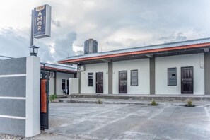 Um edifício com uma placa que diz 'AMOR' e uma área de estacionamento coberta.