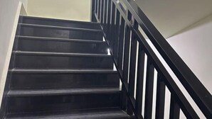 Uma escadaria com guarda-corpos e corrimão pretos.