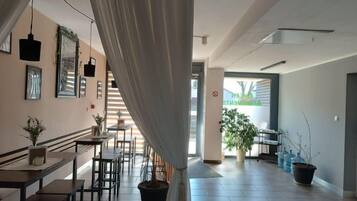 Decoração moderna com área de refeições, plantas em vasos e escada.