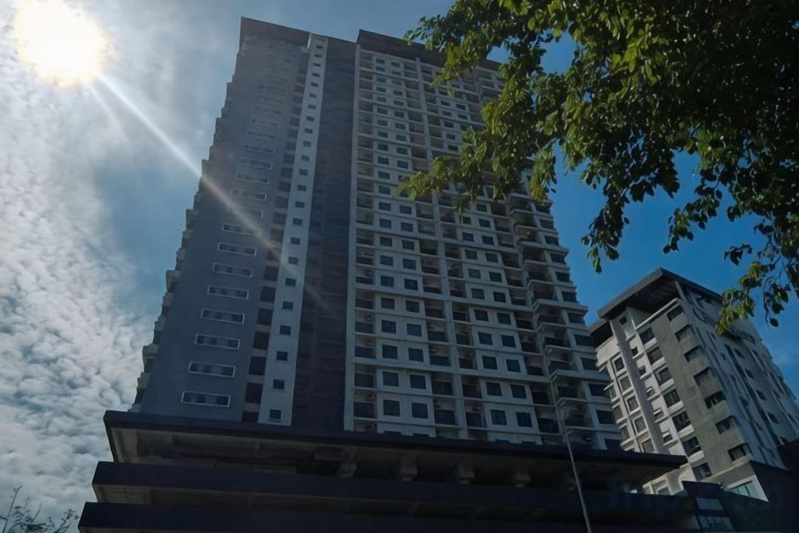 Um edifício alto com vários andares, janelas amplas e céu claro.