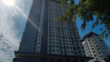 Um edifício alto com vários andares, janelas amplas e céu claro.