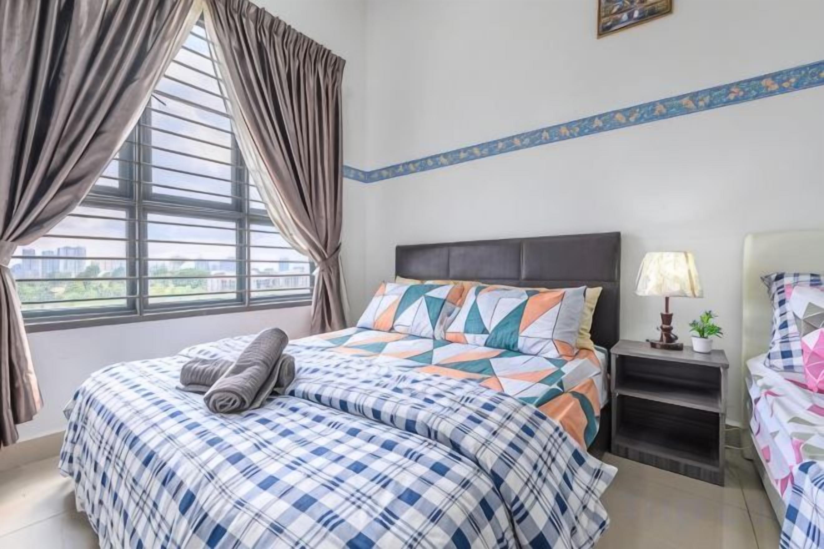 Quarto de hotel com cama, cortinas, mesa de cabeceira, abajur e vista para o exterior.