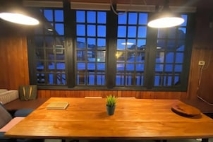 Uma mesa de madeira com uma planta, um caderno e um objeto redondo.