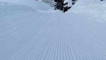 Caminho coberto de neve que leva a um edifício com telhado inclinado.