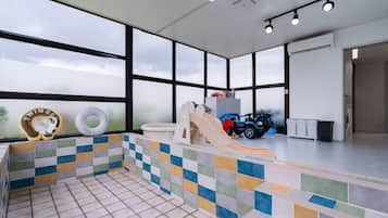 Uma área de piscina com escorrega, sanitário e um carrinho de brinquedo.