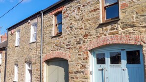 A stone building with a light blue door labeled "The Old Comstore."