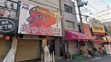 Rua com lojas fechadas, algumas com placas em japonês.