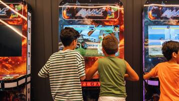 Um salão de jogos eletrônicos com várias telas exibindo diferentes jogos.