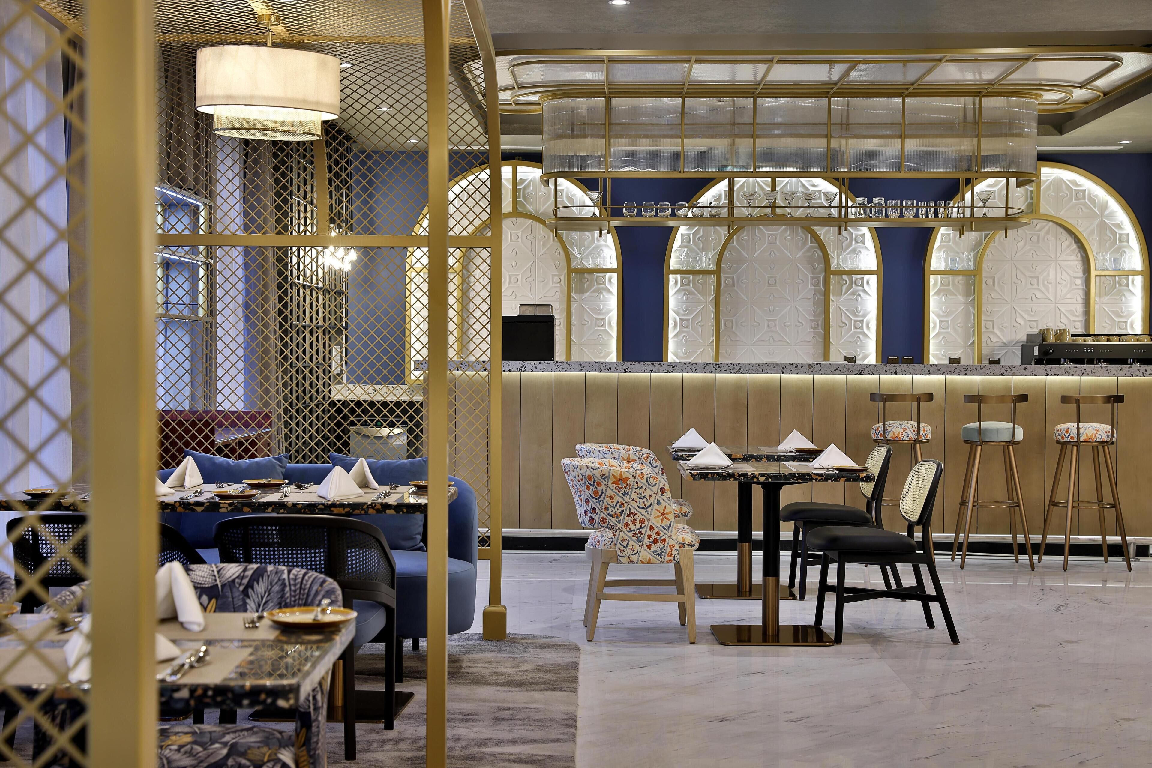 Restaurante com interior moderno, apresentando uma variedade de opções de assentos, incluindo cabines e mesas altas.
