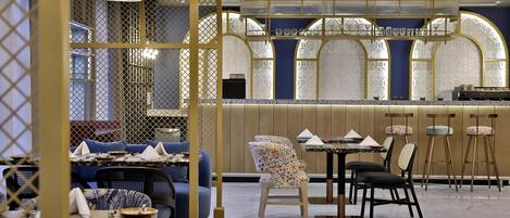Restaurante com interior moderno, apresentando uma variedade de opções de assentos, incluindo cabines e mesas altas.