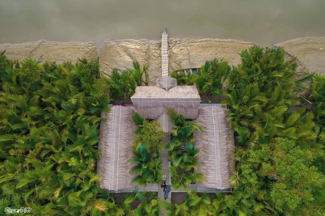 Vista aérea de um resort com uma estrutura central rodeada por vegetação exuberante.