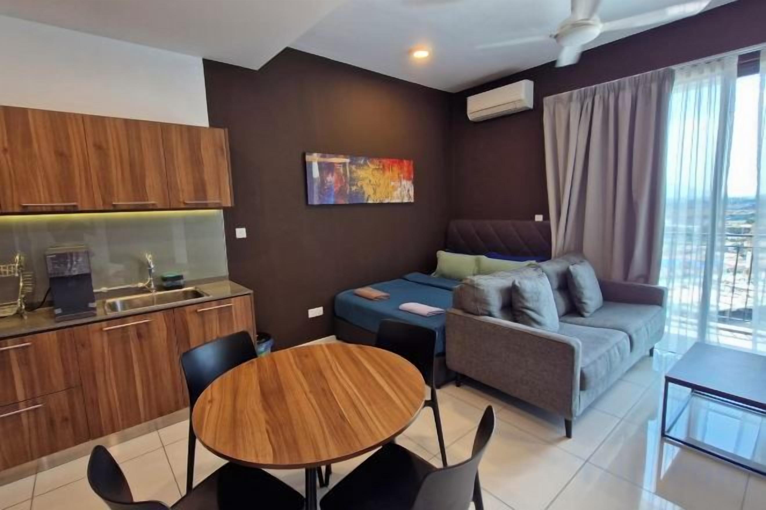 Espaço compacto com cozinha compacta, sofá, mesa de jantar e vista para o exterior.