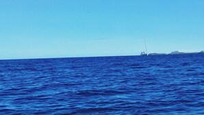 Um veleiro em um mar calmo sob um céu limpo.