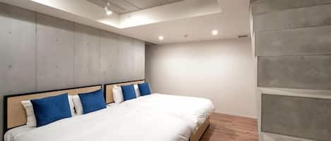 Quarto moderno com uma cama grande, piso de madeira e parede cinza.