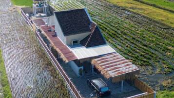 Um edifício grande com uma área externa coberta, próximo a um campo.