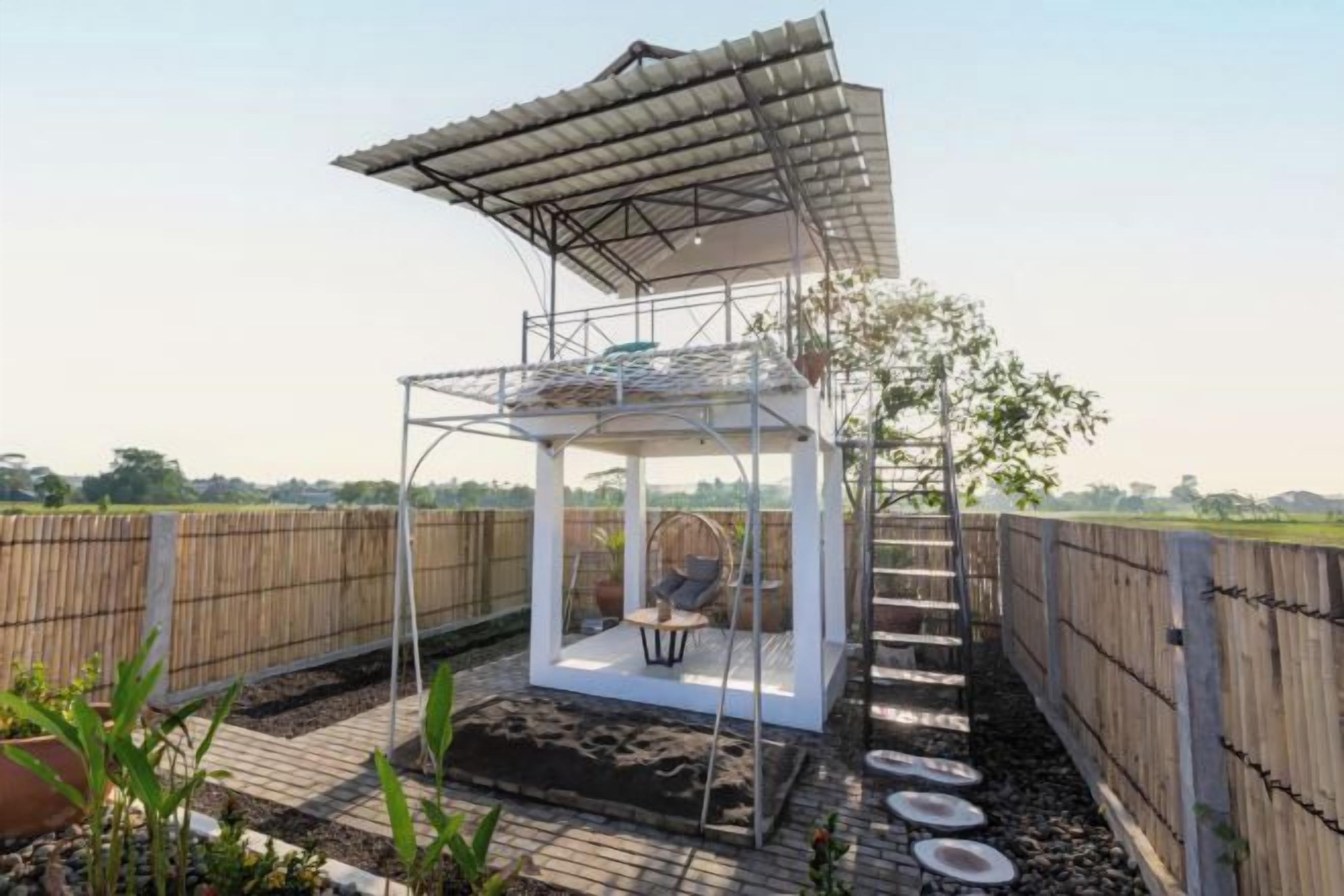 Um gazebo com cobertura, espaço para sentar e vista para a paisagem ao redor.