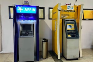 Caixa eletrônico e máquina de depósito de dinheiro com um aviso de segurança acima.