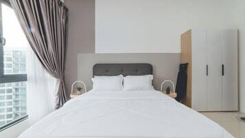 Um quarto moderno com uma cama grande, cabeceira, mesa de cabeceira com abajur, uma pequena planta e um guarda-roupa.