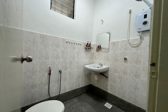 Casa de banho com sanita, lavatório, espelho e toalheiro.
