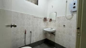 Casa de banho com sanita, lavatório, espelho e toalheiro.