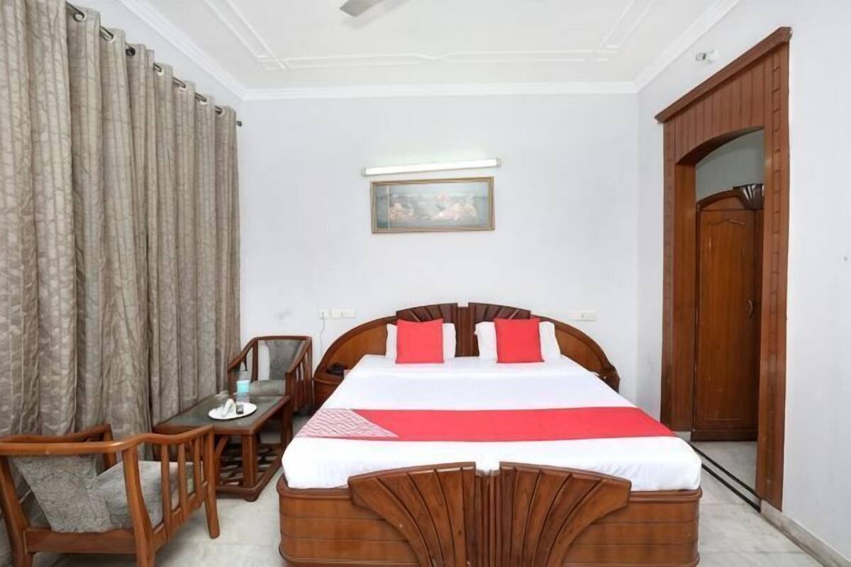 Quarto de hotel com uma cama, uma mesa, uma cadeira, um guarda-roupa e um quadro na parede.
