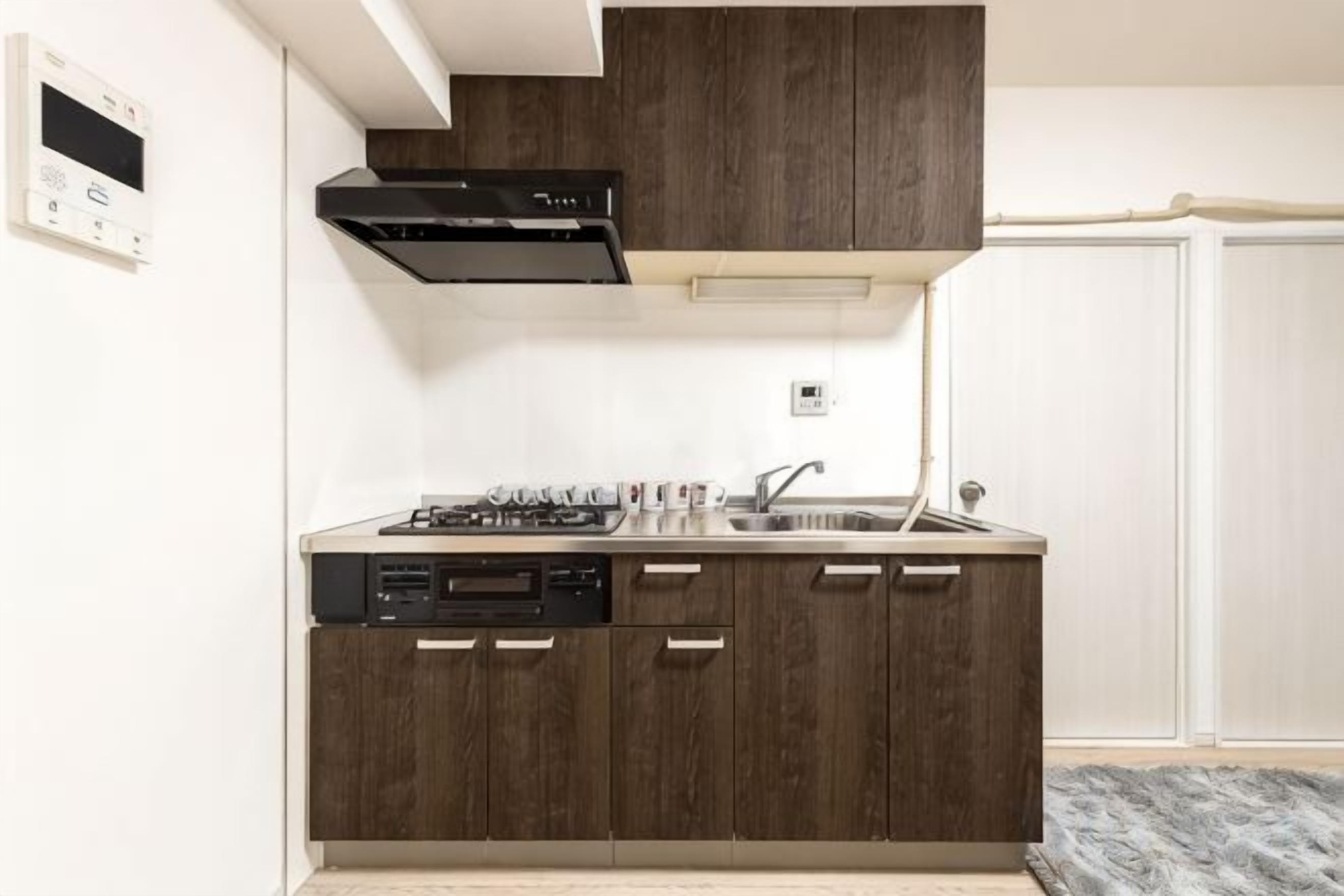 Cozinha compacta com fogão embutido, pia e armários.
