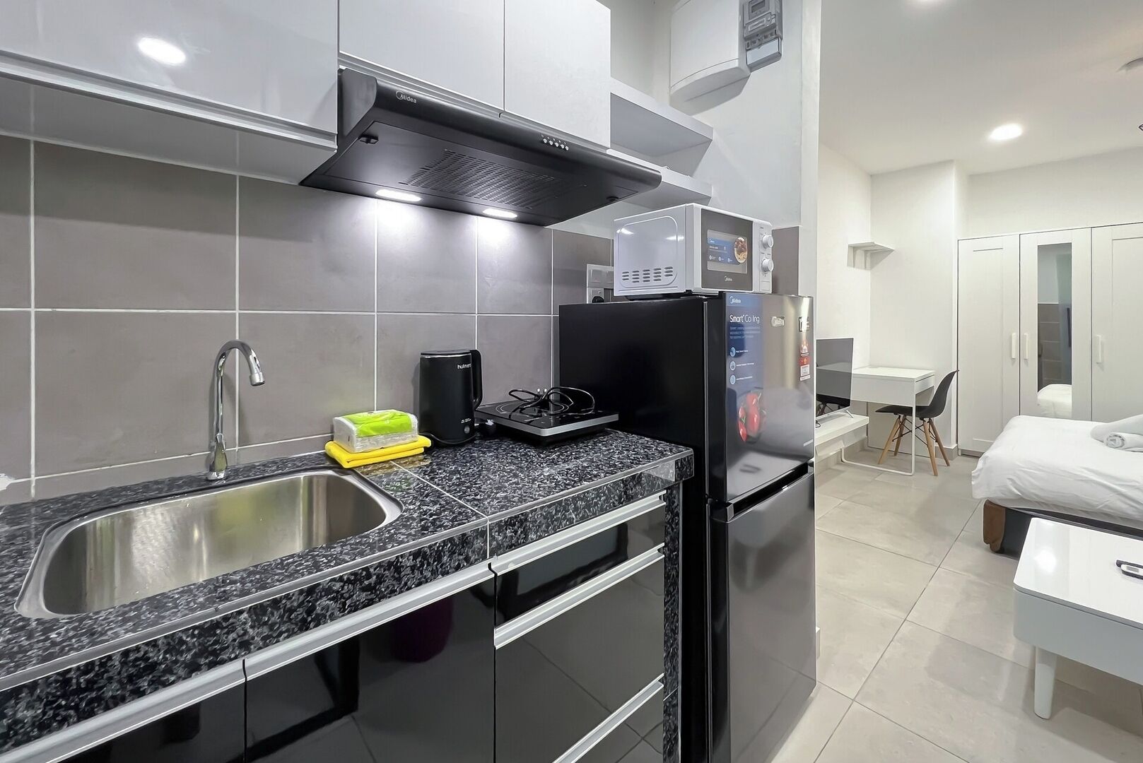 Uma cozinha moderna com pia de aço inoxidável, fogão embutido e geladeira.