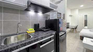Uma cozinha moderna com pia de aço inoxidável, fogão embutido e geladeira.