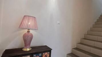 Uma escada com uma luminária sobre um armário.