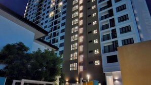 Um edifício alto com vários andares, cada um iluminado por luzes internas.