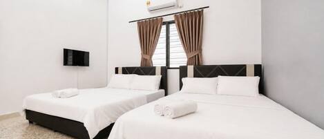 Quarto de hotel com duas camas, televisão de tela plana e janela com cortinas.
