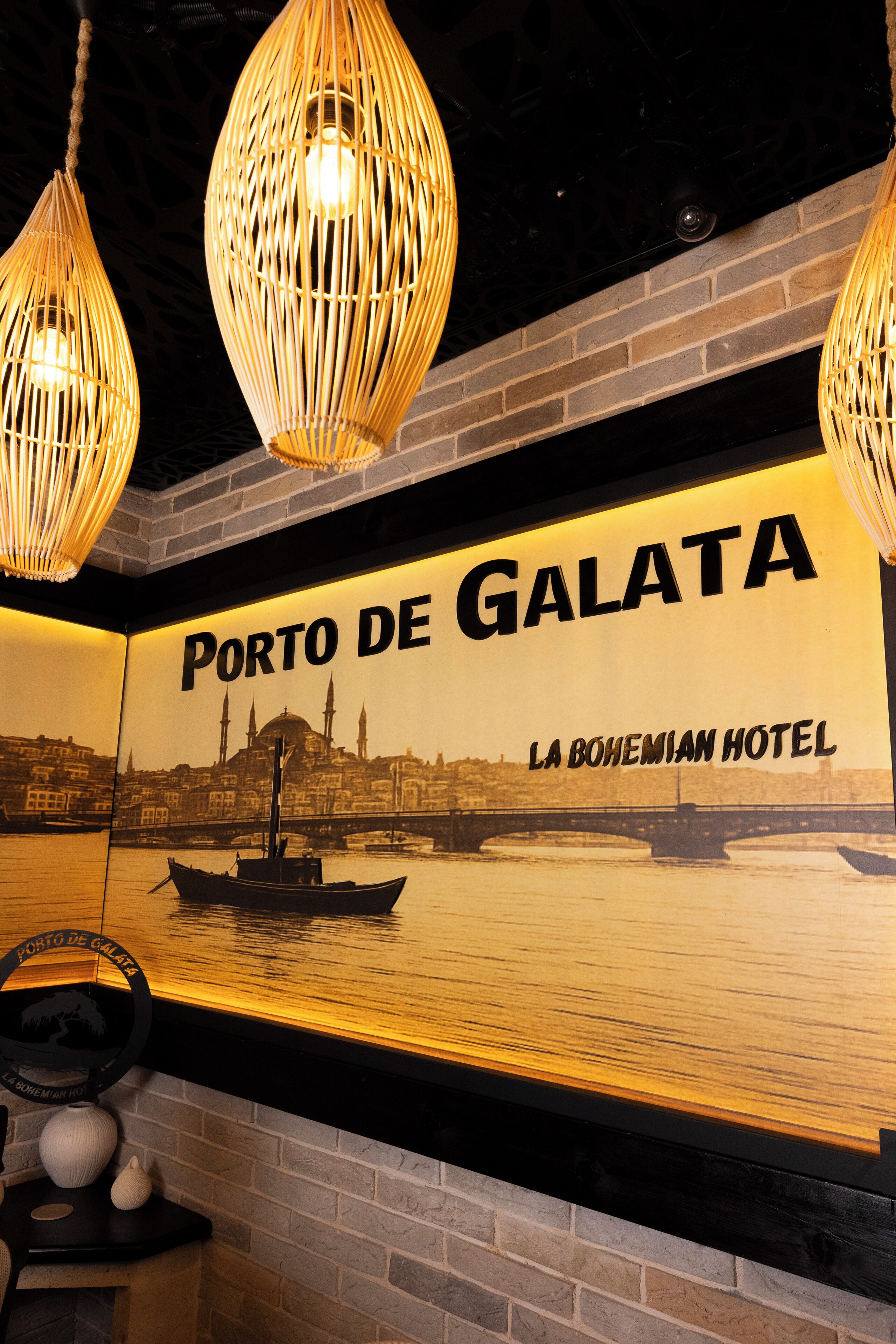 Parede com um mural de uma paisagem urbana e o texto 'PORTO DE GALATA LA BOHEMIAN HOTEL'.