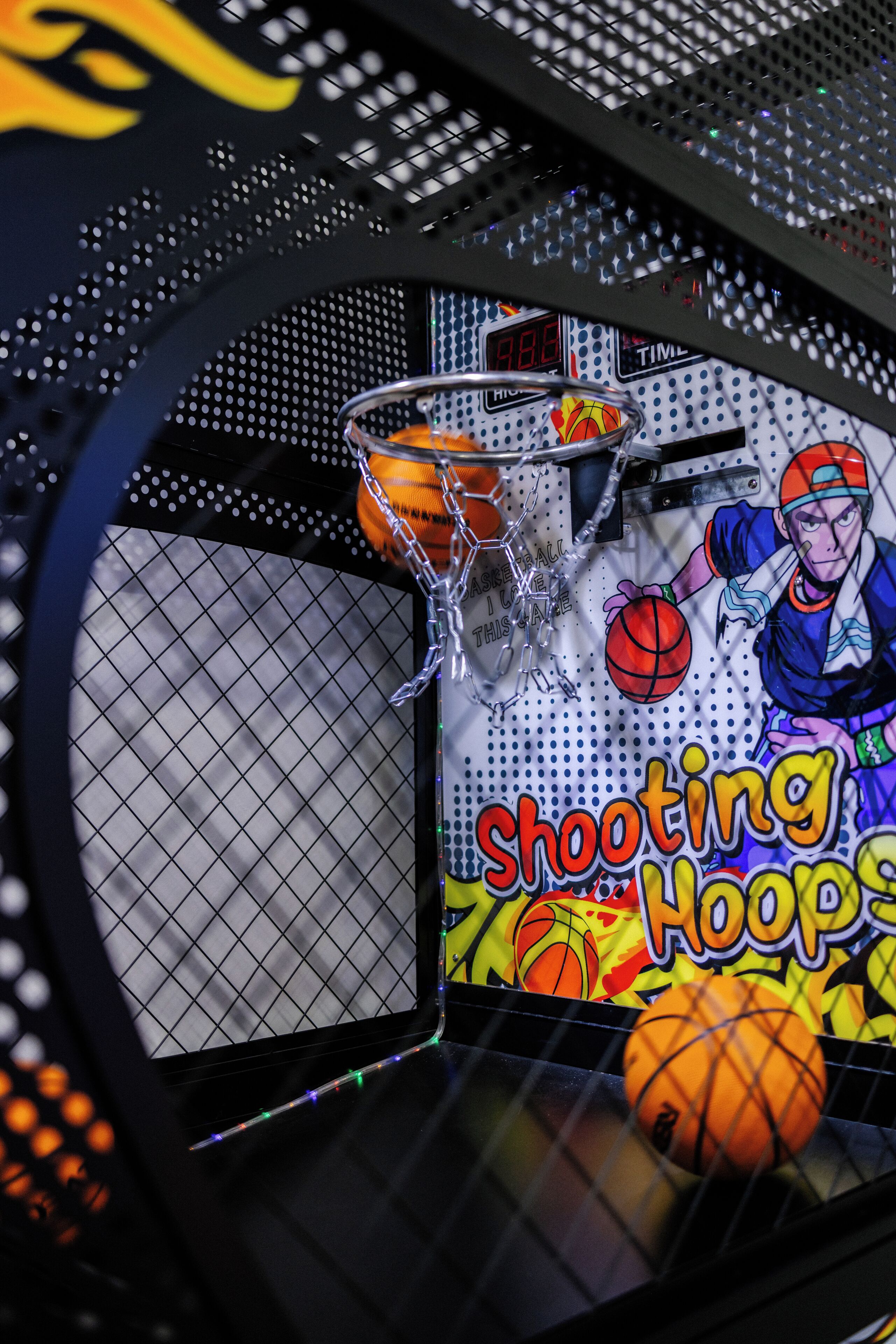 Jogo de basquete em fliperama, com uma cesta e um cronômetro digital.