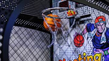 Jogo de basquete em fliperama, com uma cesta e um cronômetro digital.
