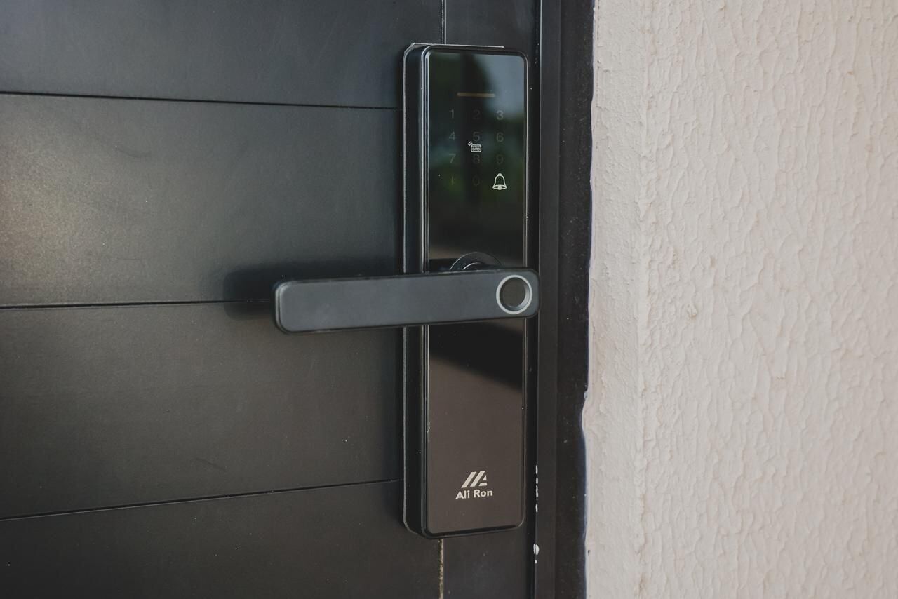Uma porta moderna com fechadura digital e puxador.