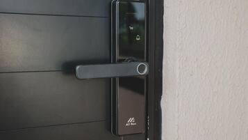Uma porta moderna com fechadura digital e puxador.